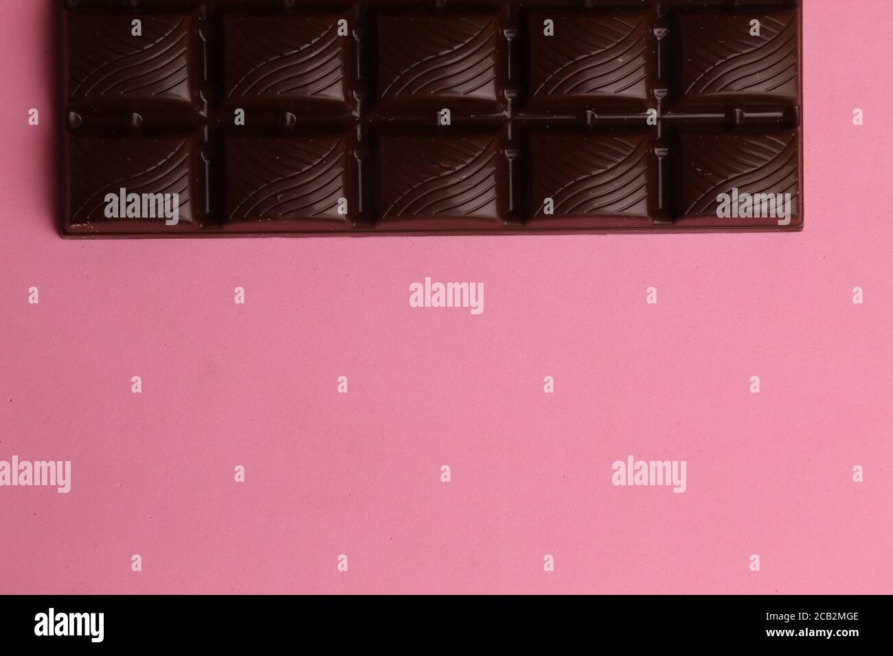 Sweet, brown chocolate bars on the pink surface Stock Photo - Alamy