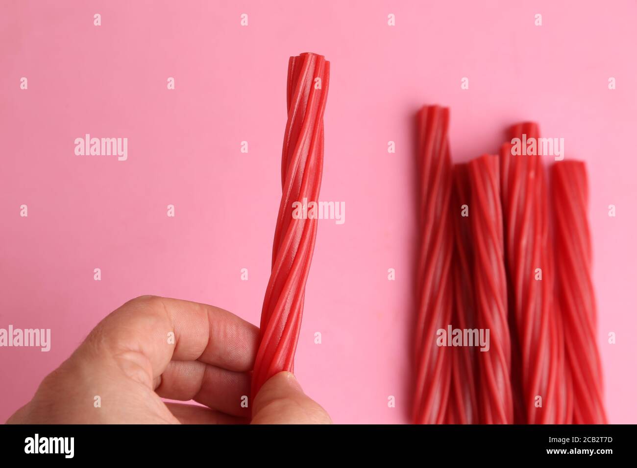 Closeup shot of sweet red licorice candy on a pink background Stock ...