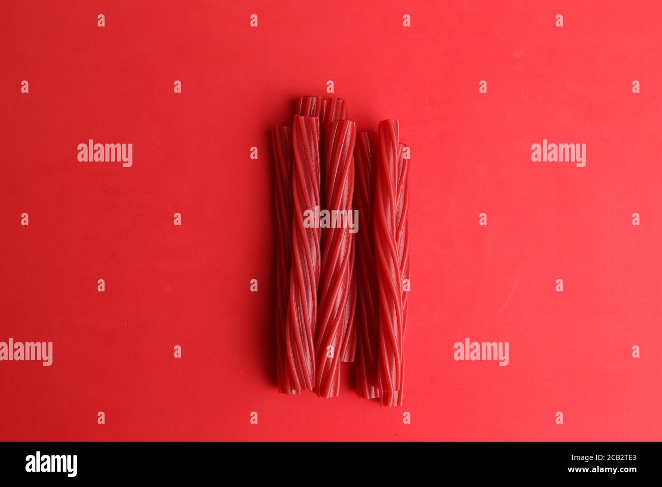 Top view of the red licorice sticks on a red background Stock Photo - Alamy