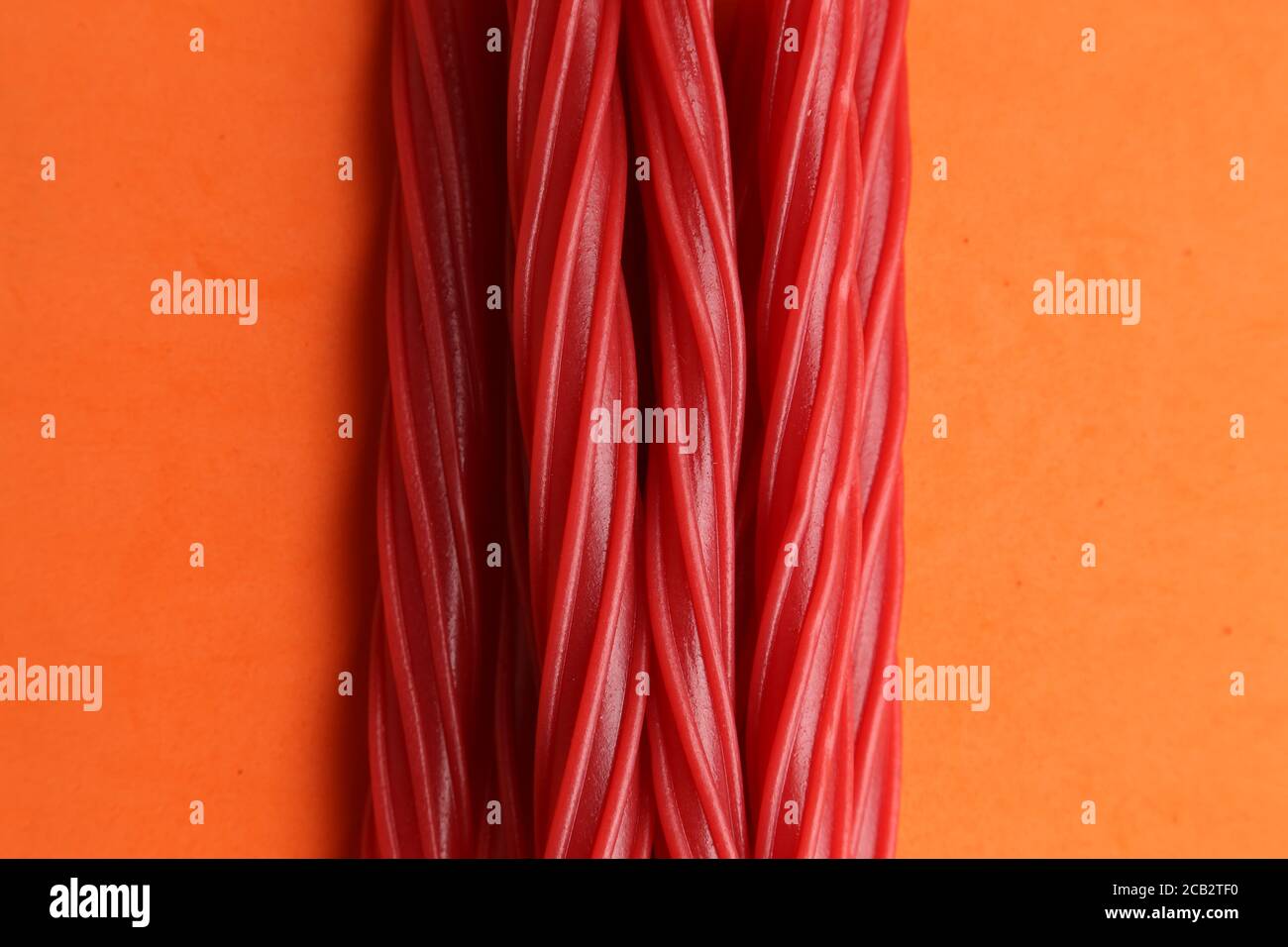 Closeup shot of red candy sticks on an orange surface Stock Photo - Alamy