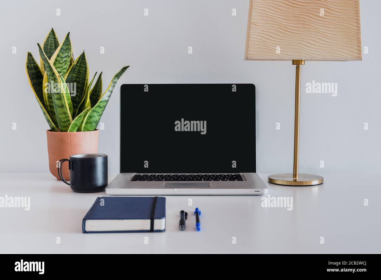 Desk with a laptop and office materials Stock Photo - Alamy