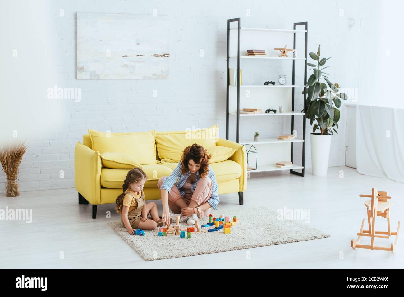 selective focus of babysitter and child playing with multicolored ...