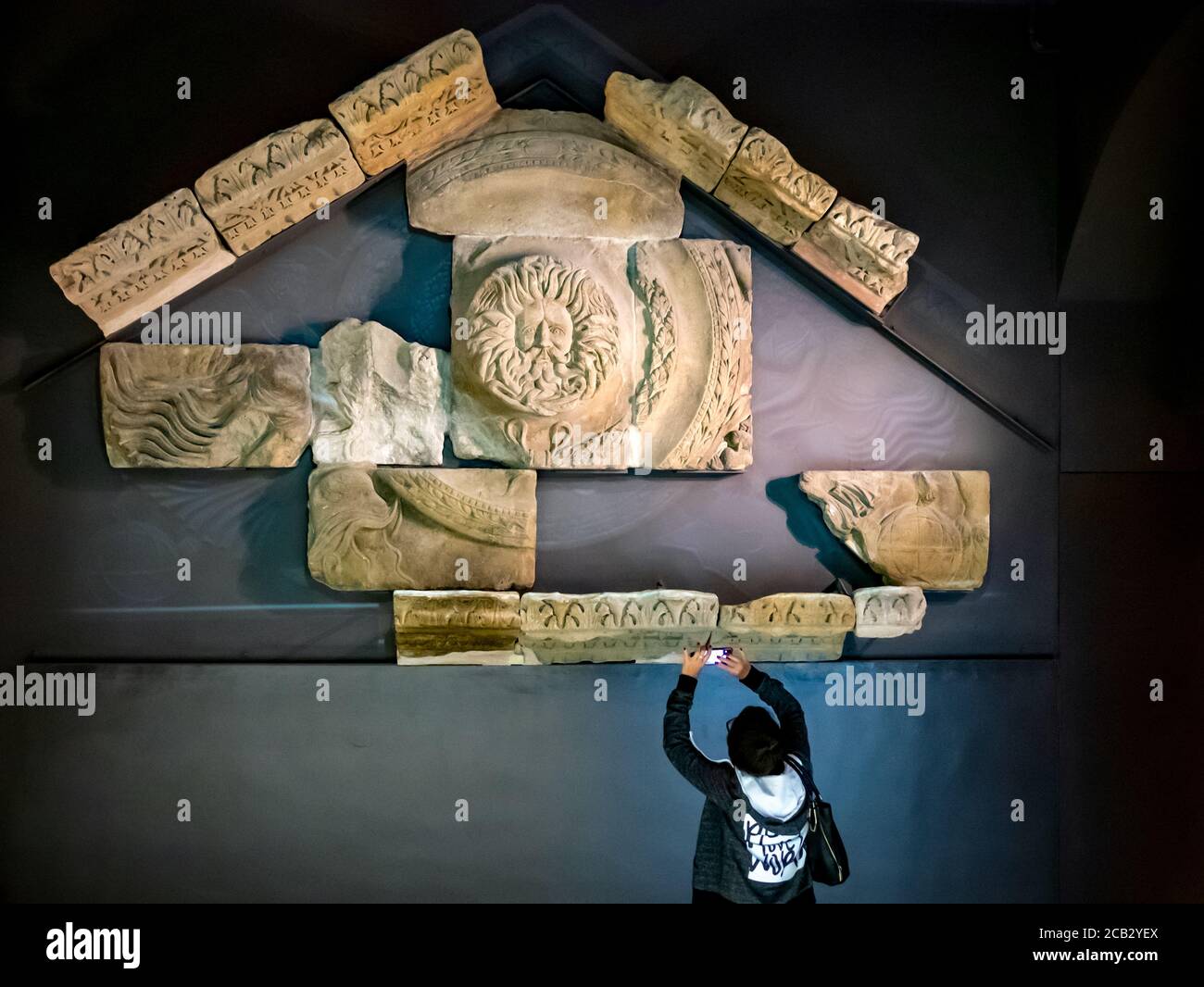 Tourist photographing the Gorgon's Head in the Temple of Sulis Minerva ...