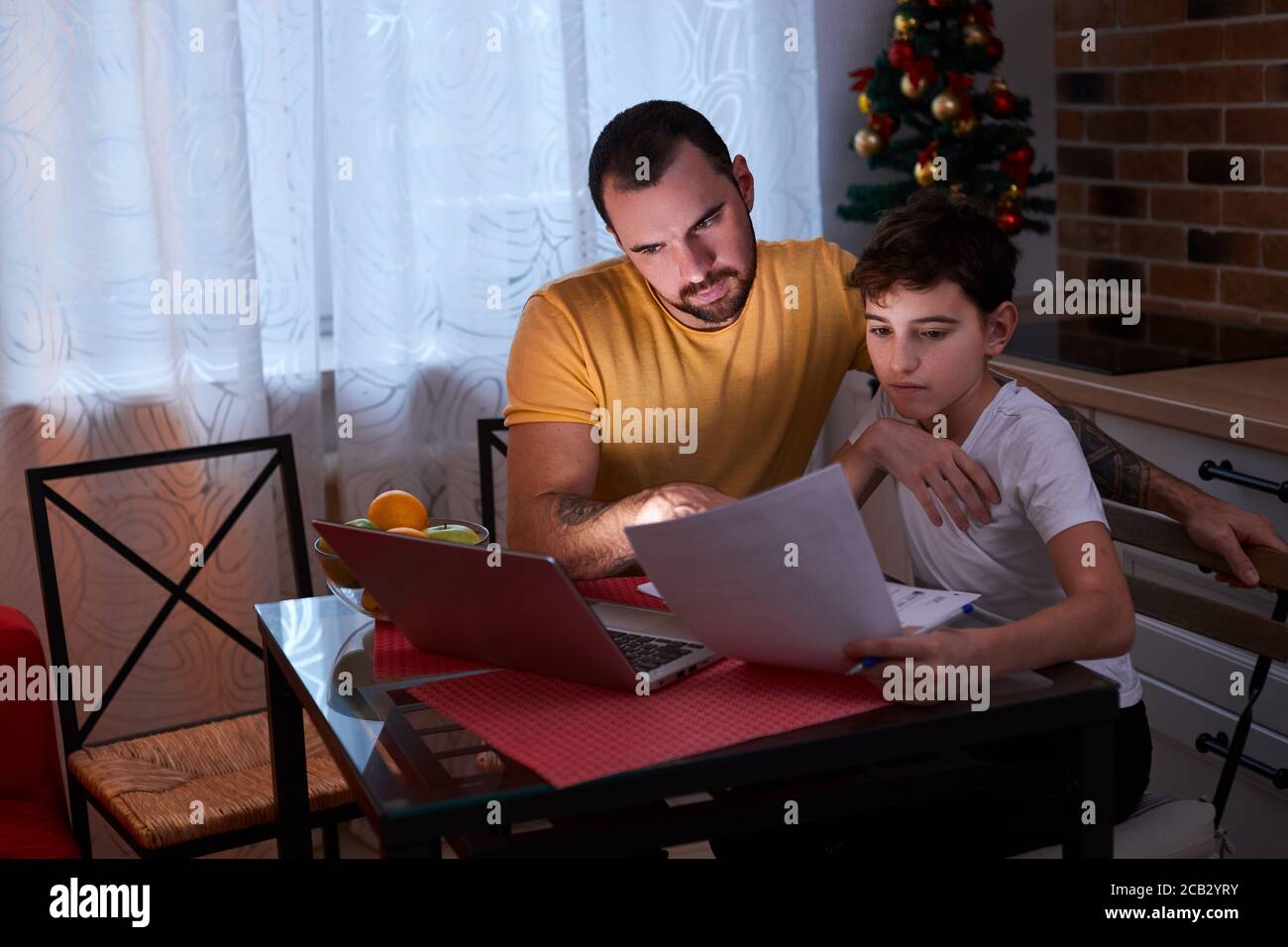 attentive father help his son to do homework, to study at home, using ...