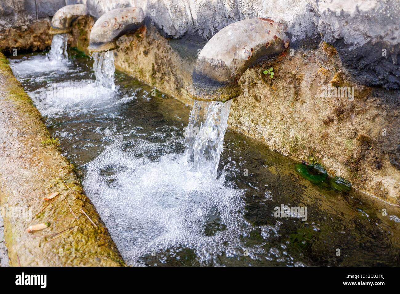 Old fresh water jets at a public fountain in the mountains Stock Photo ...