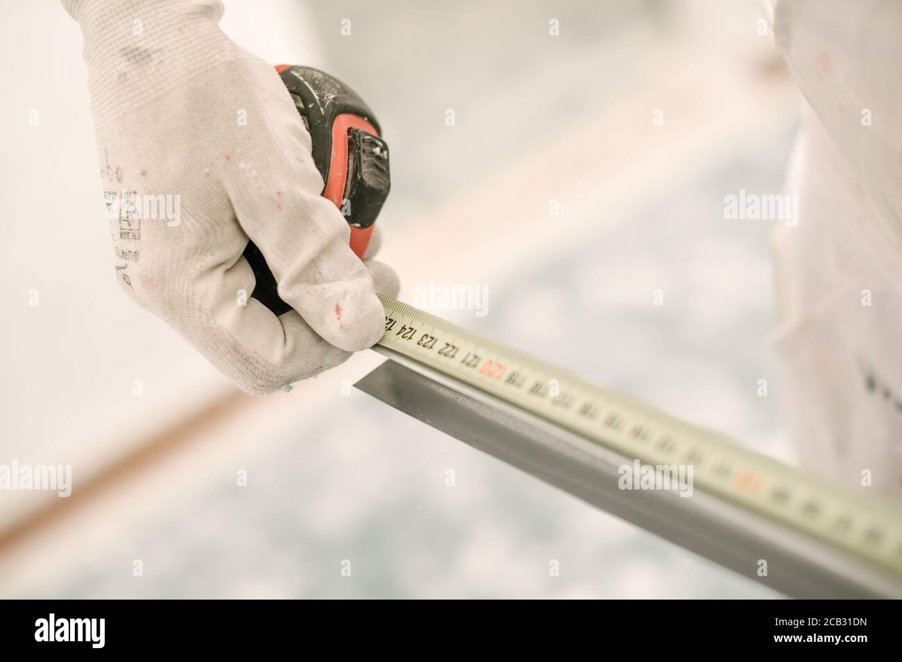 Construction worker using measuring tape. Close up Stock Photo - Alamy