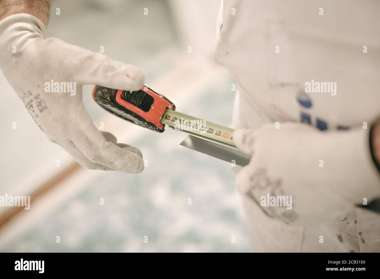 Construction worker using measuring tape. Close up Stock Photo - Alamy