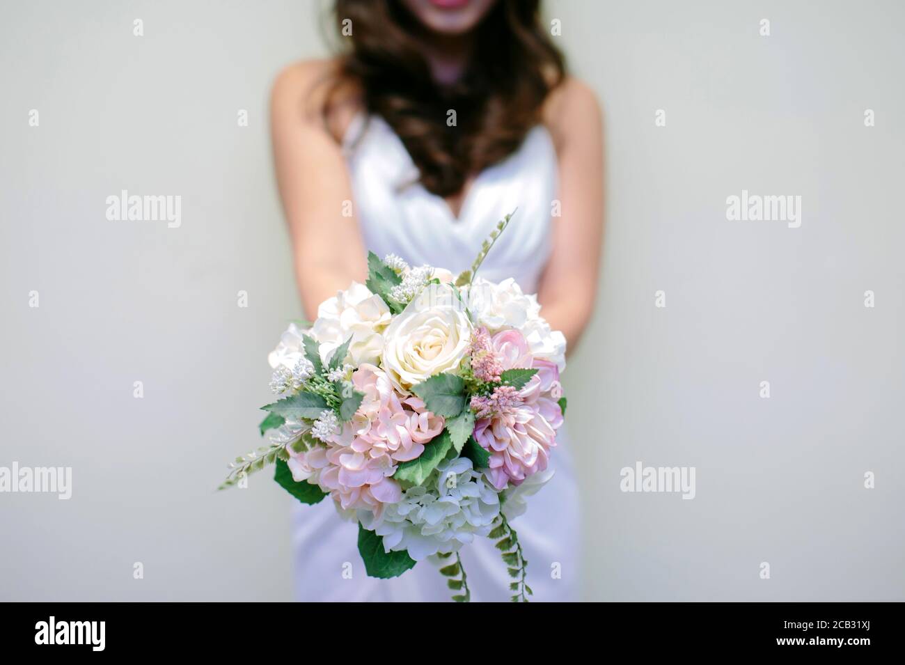 Close up focus on the white roses flower bouquet being held by an ...