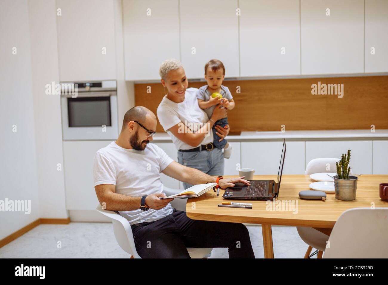 FBeautiful family at home use laptop for working from home. White ...