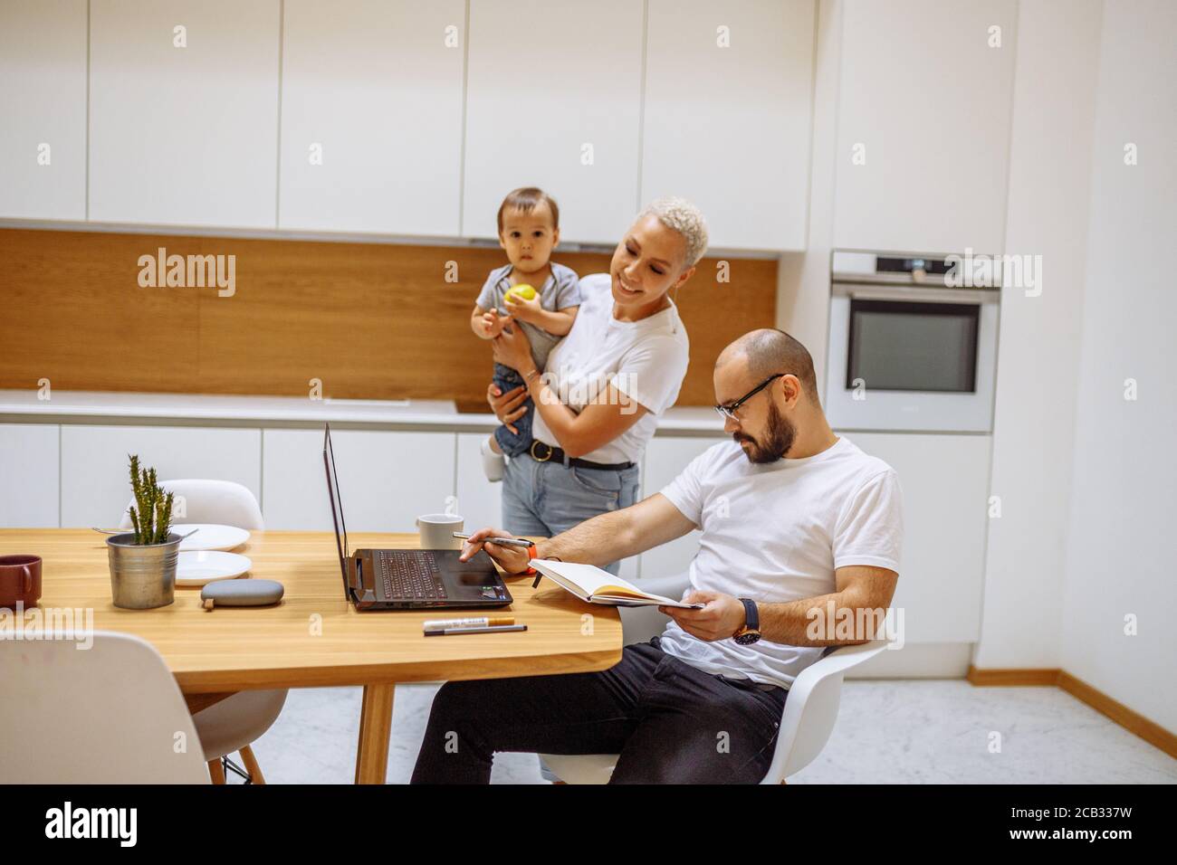 FBeautiful family at home use laptop for working from home. White ...