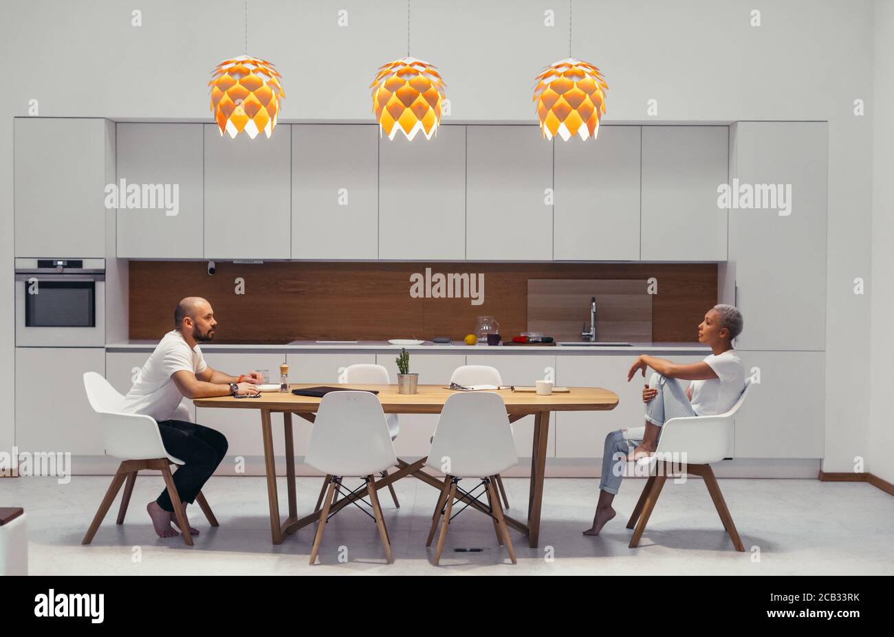 Lovely family couple, wife and husband sit opposite on another and look ...