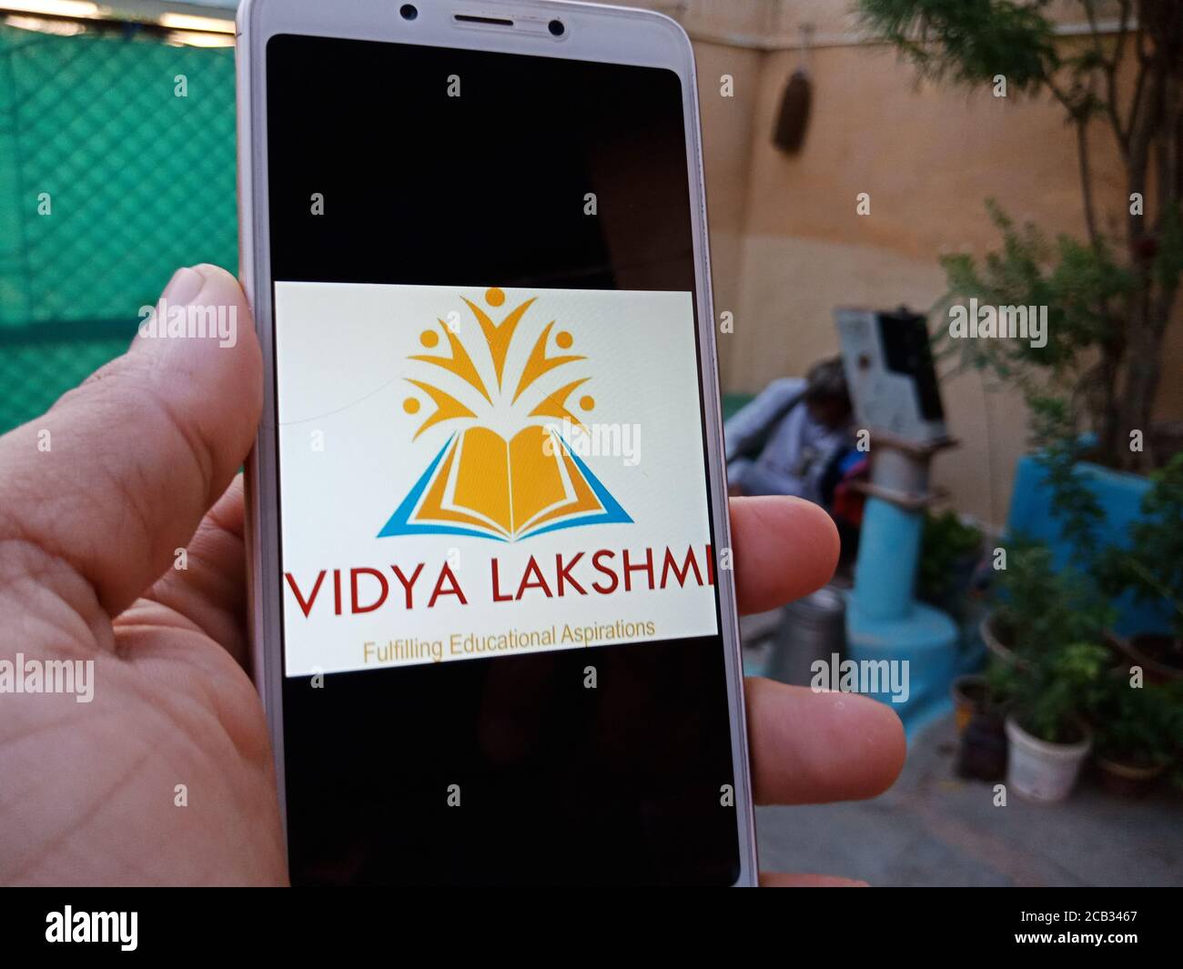 DISTRICT KATNI, INDIA - MAY 23, 2020: Woman holding smart phone with displayed vidhya laxmi ...