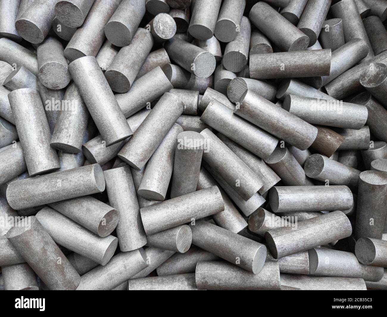 a pile of sand blasted stainless steel rods - closeup with selective ...