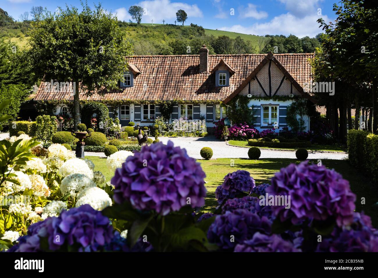 Pretty house in large flower garden with blue sky in summer Stock Photo ...