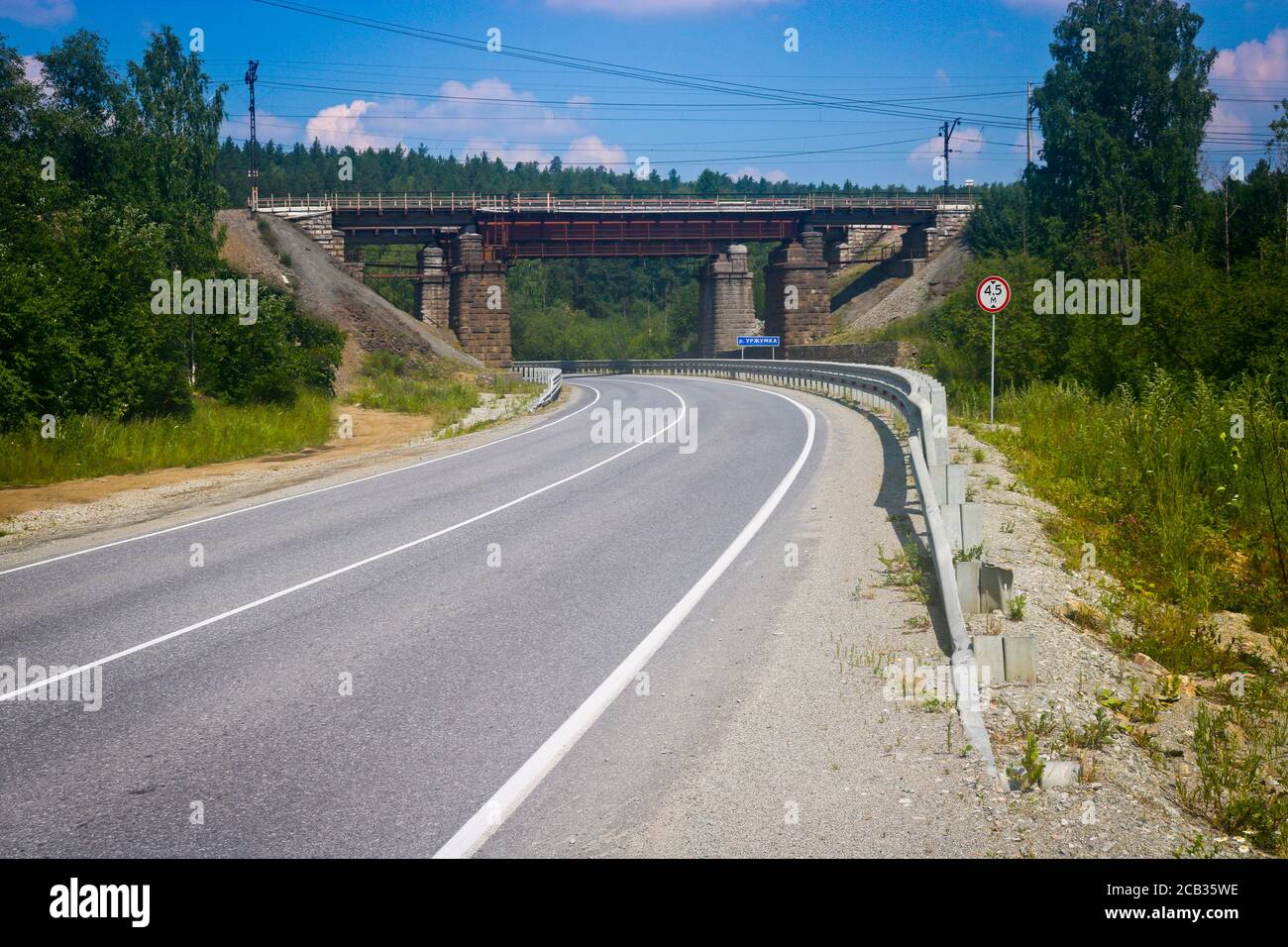 Autostrada with a turn, going under the vintage railway bridge over the ...