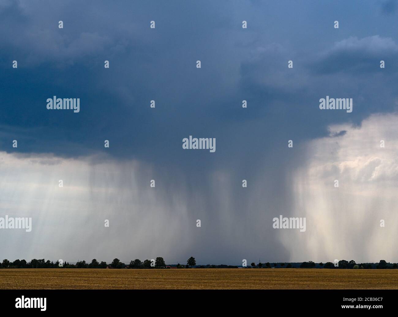 Brandenburg, Germany. 10th Aug, 2020. Precipitation falls from a dark ...