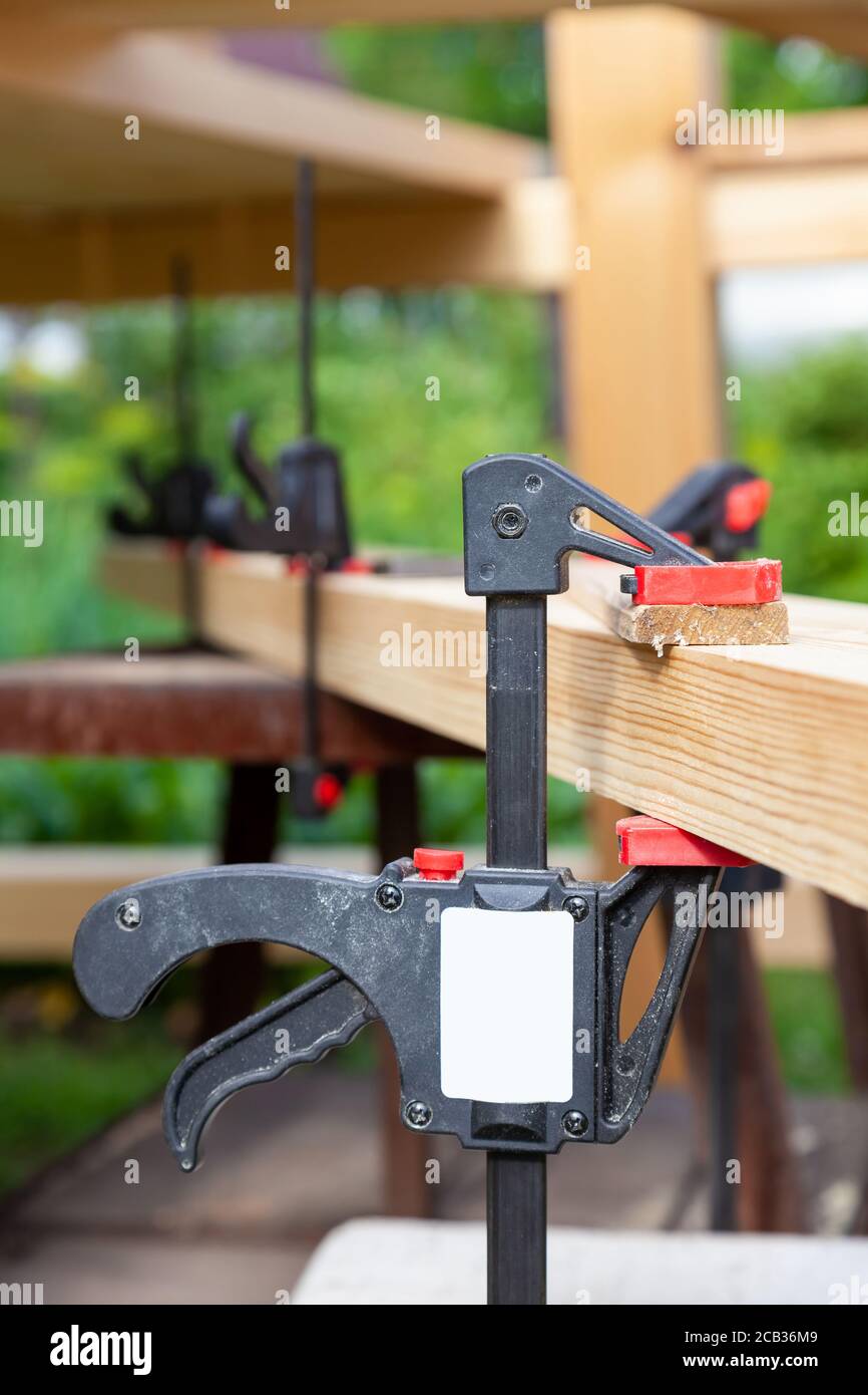 Several clamps on wooden beams and timber during the construction of a ...
