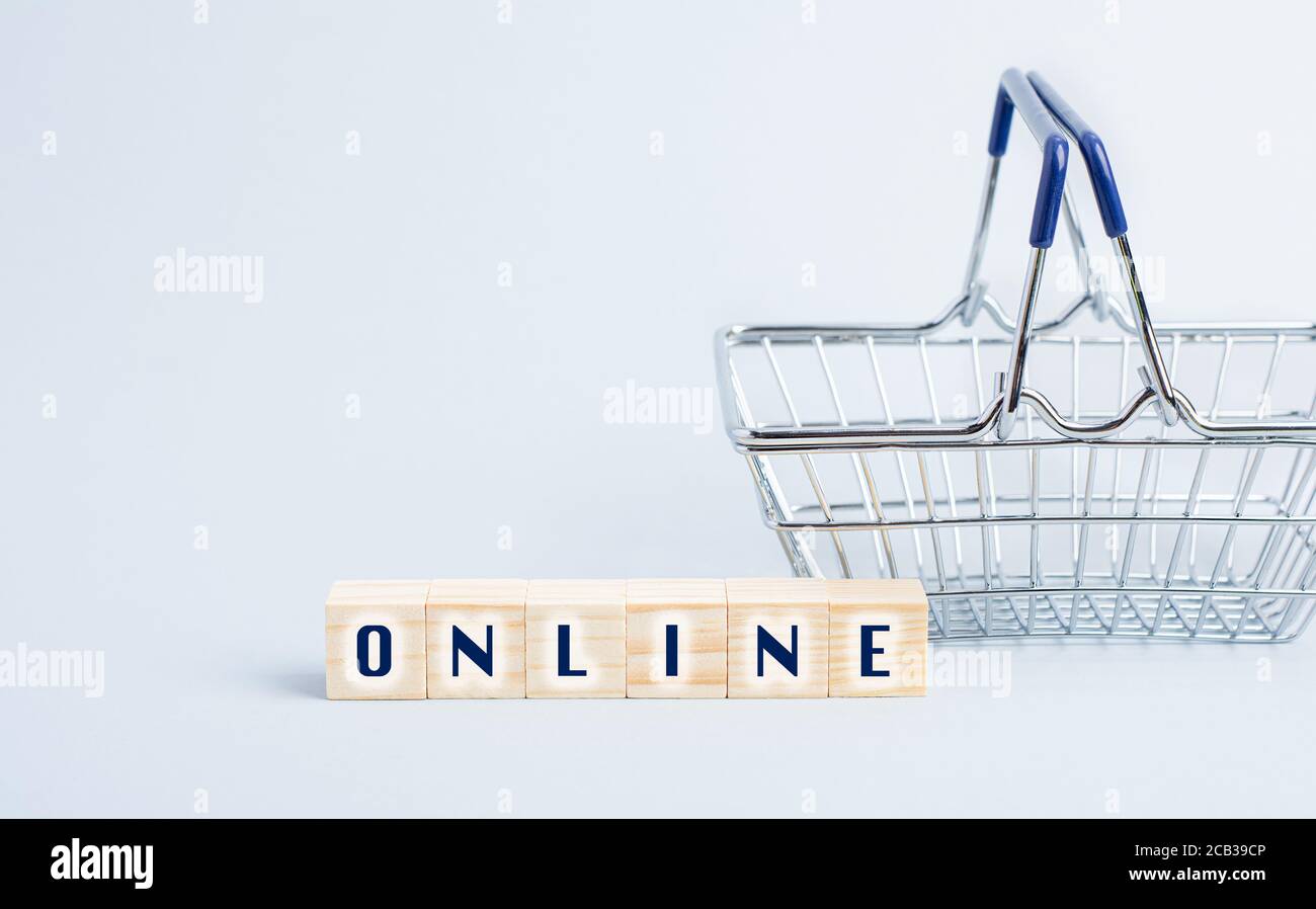 A shopping basket and wooden blocks on a grey background Stock Photo ...