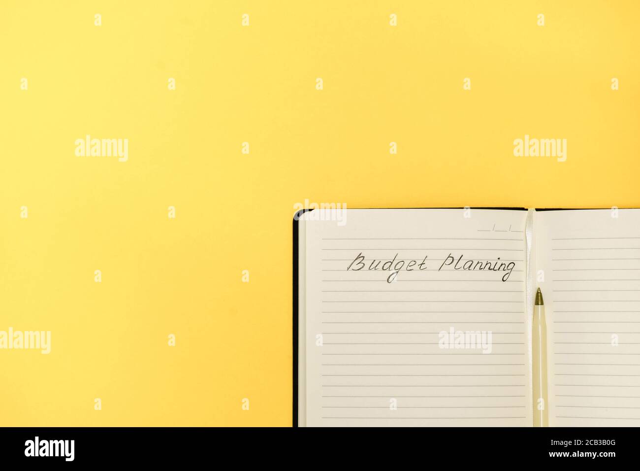 Handwritten words Budget Planning in a notepad on yellow background ...