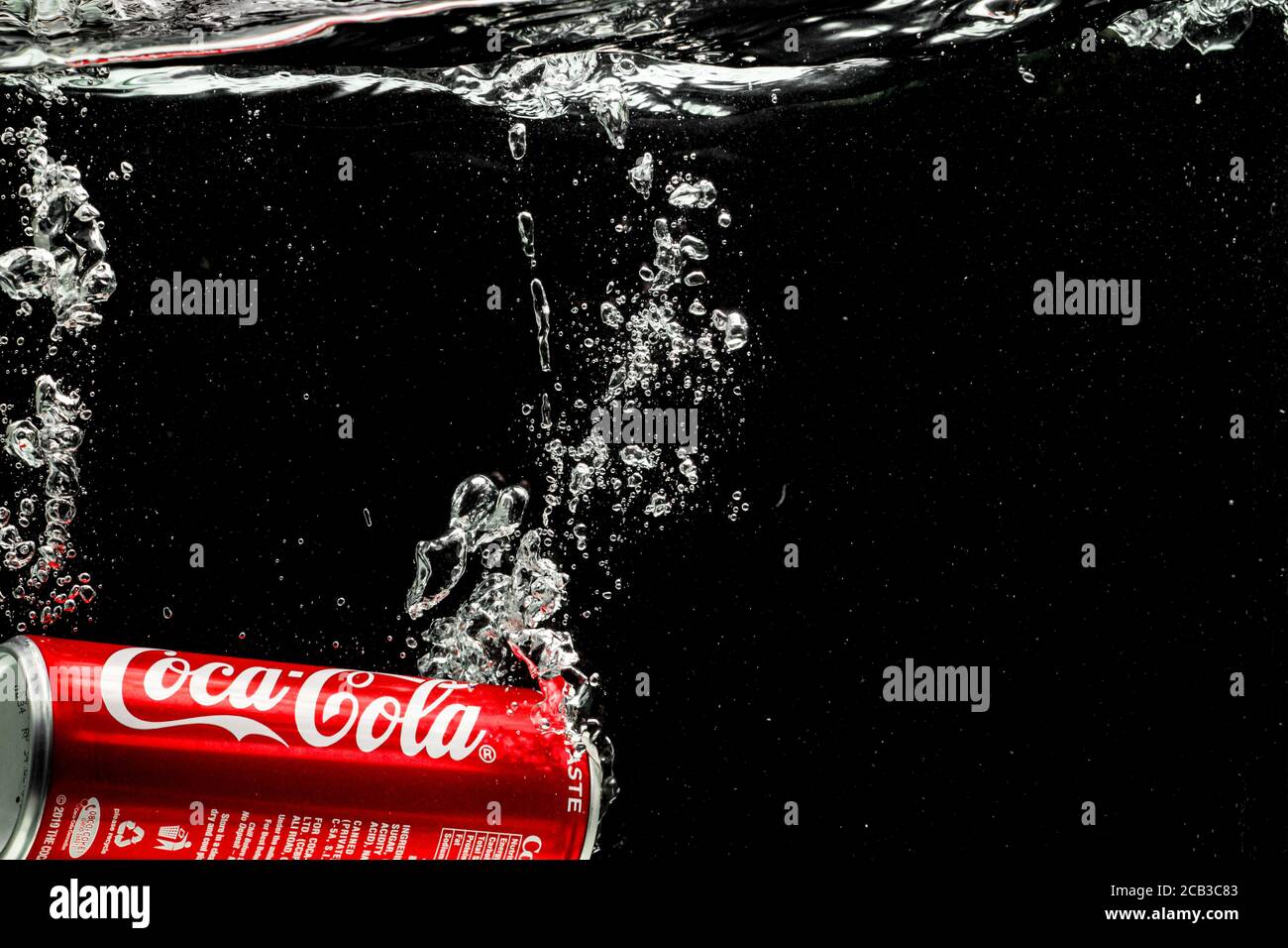 Coca cola can splashing in to water on black background Stock Photo - Alamy