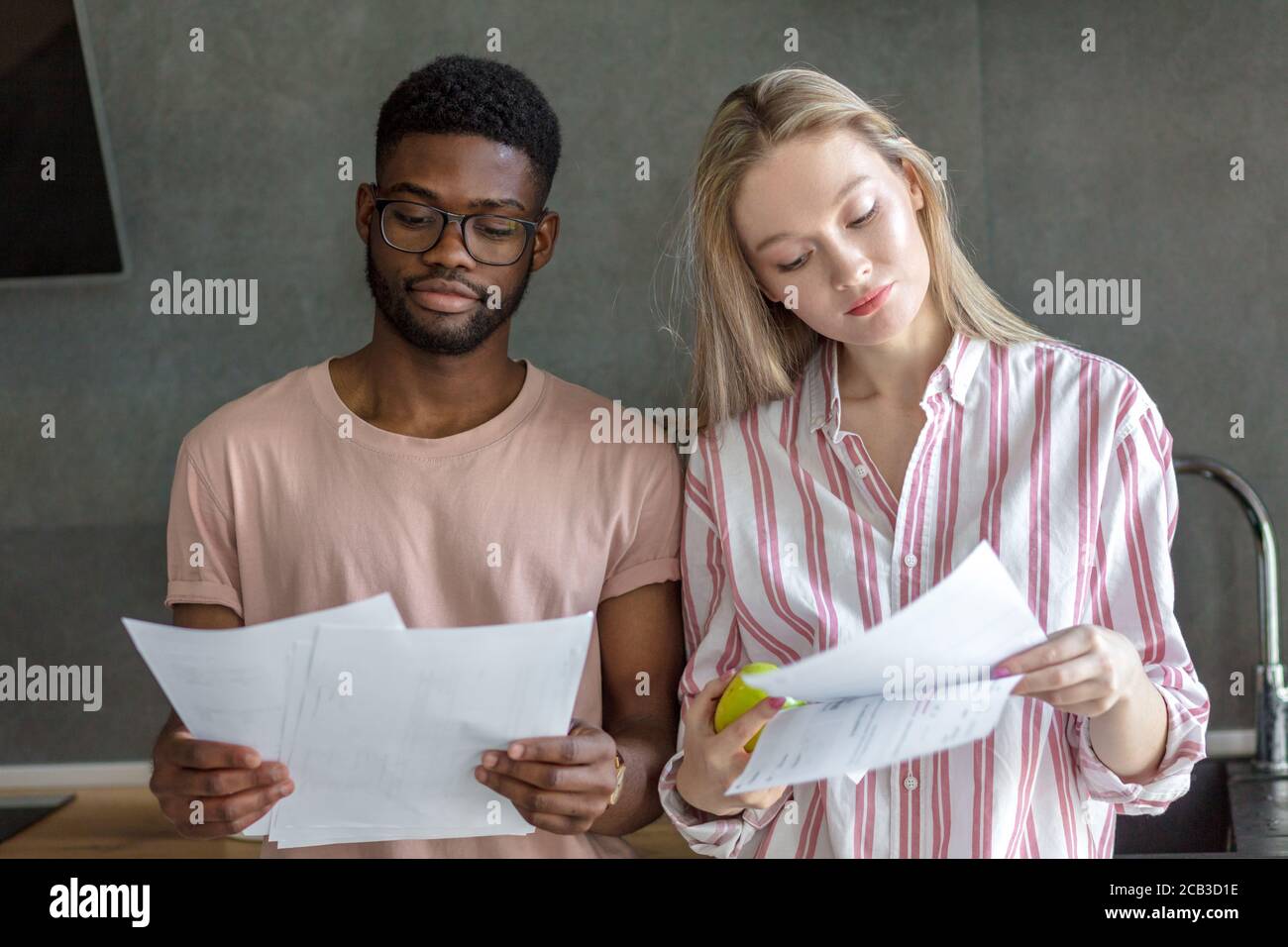 Young mixed-race couple of diverse students in casual wear, sitting ...