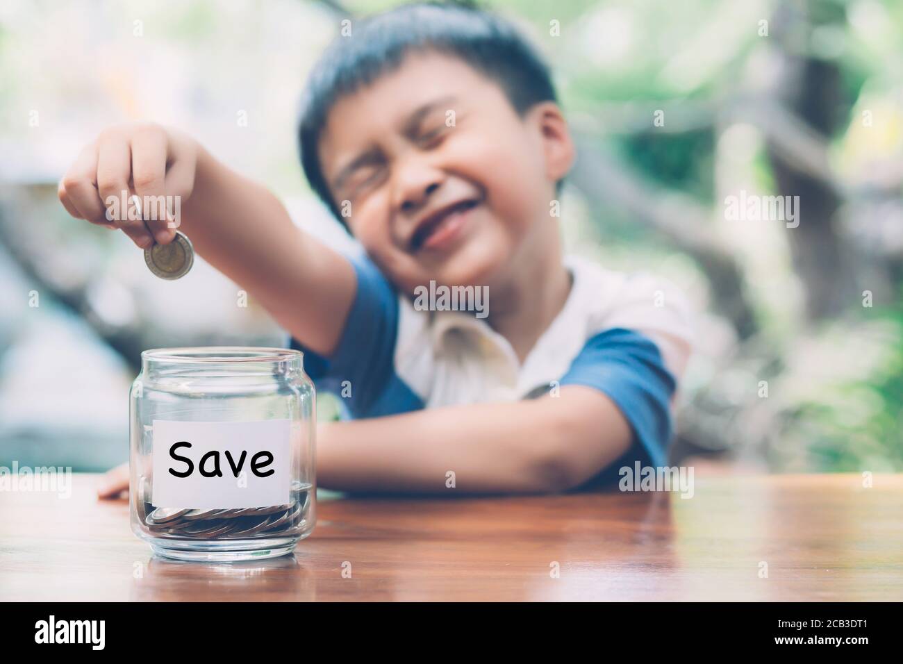 Happy asian children saving money putting coin in glass for wealth and ...