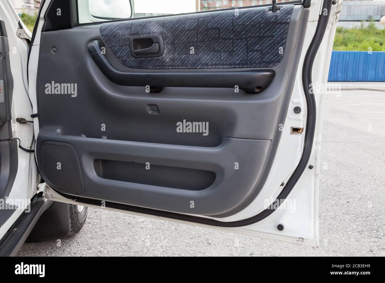 Close-up of an open rear door of a Japanese car with black plastic trim ...