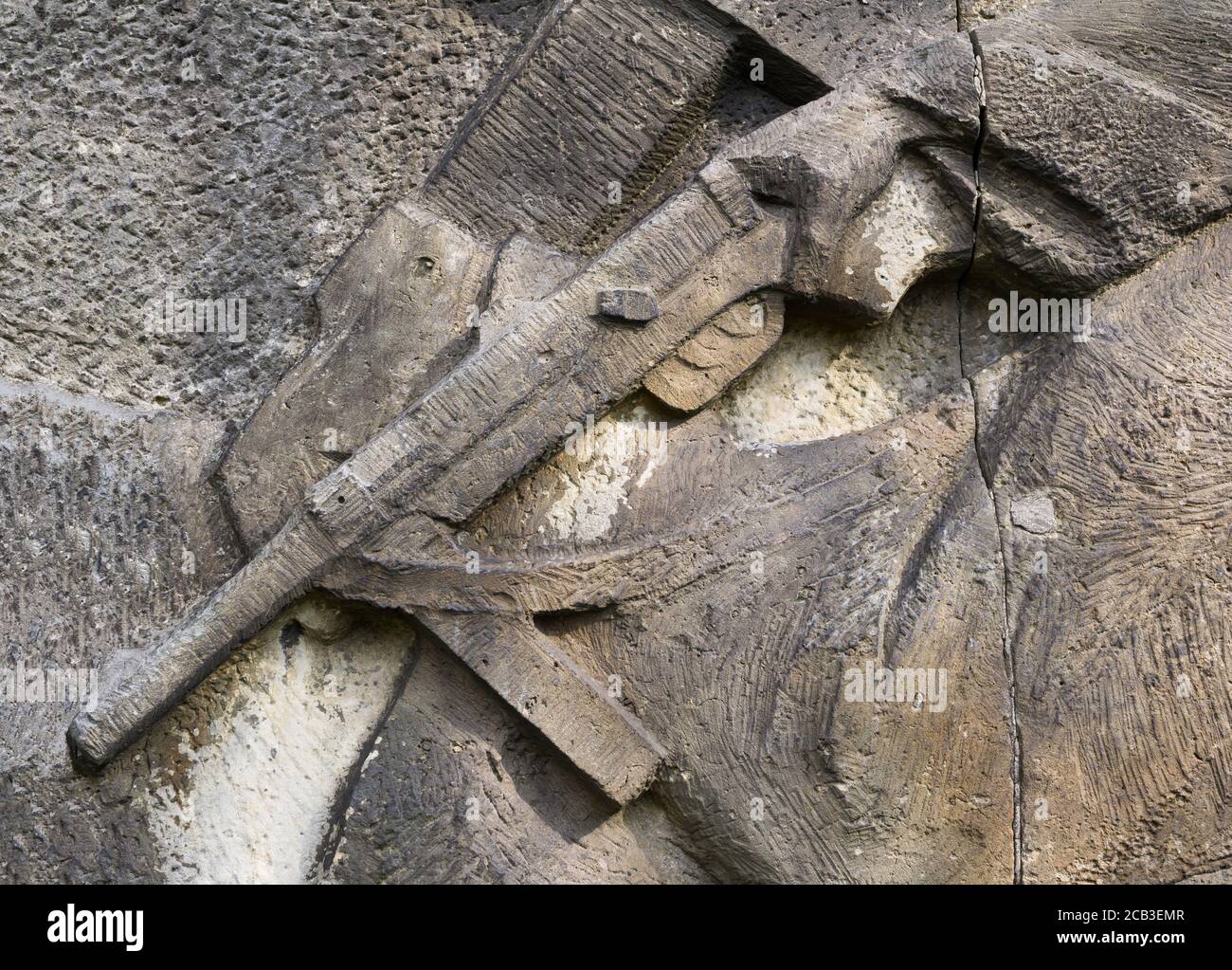 Machine gun - detail of relief in the stone - hand of soldier is ...