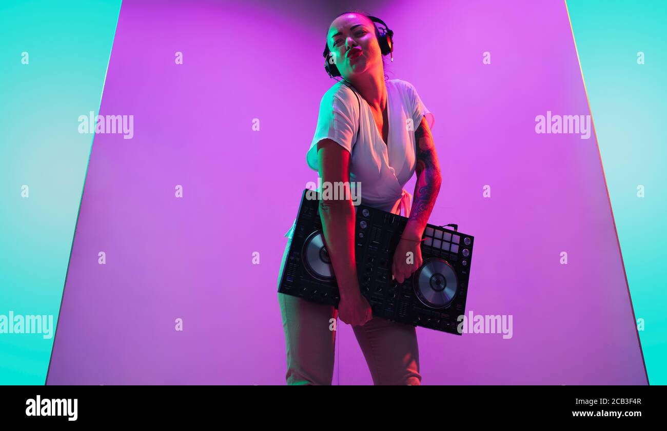 Happiness. Young female musician in headphones performing on purple ...