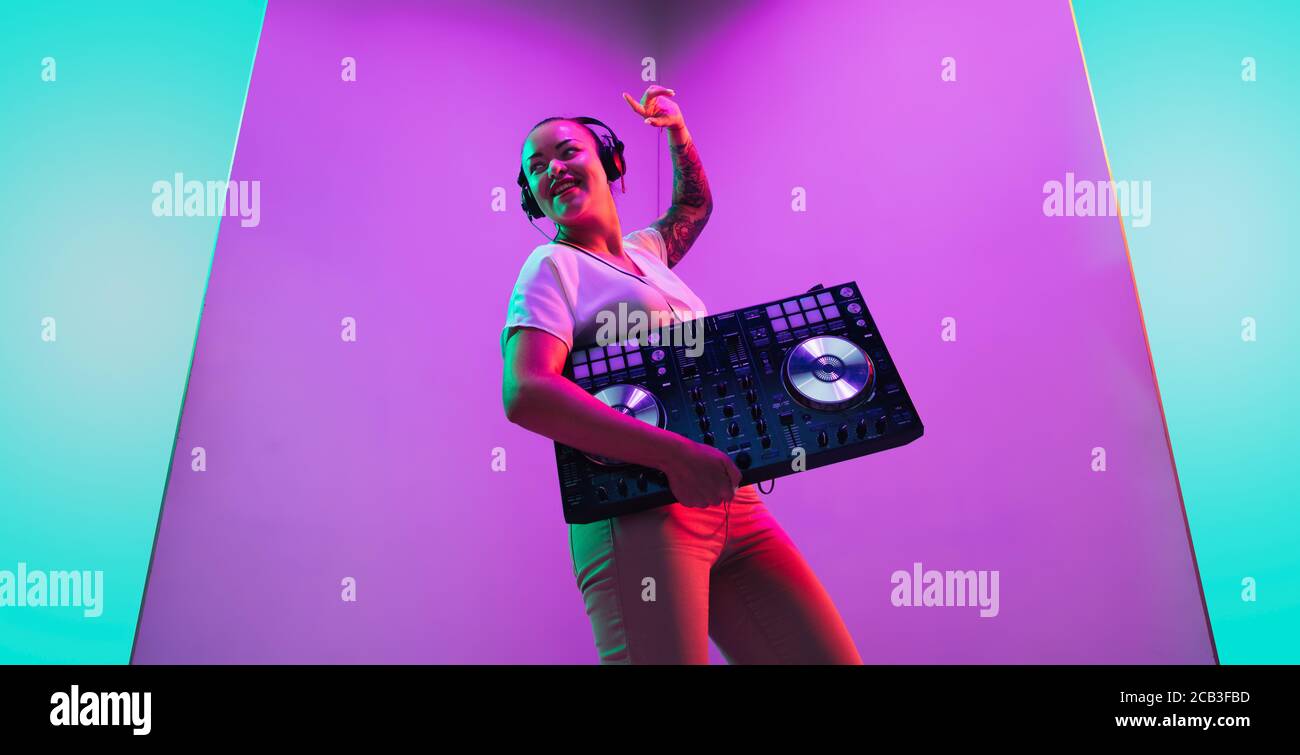 Happiness. Young female musician in headphones performing on purple ...