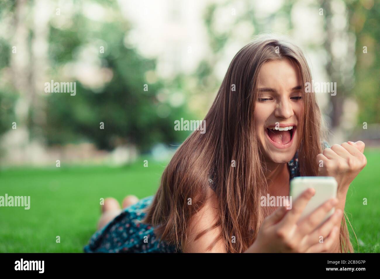 Excited beautiful girl receiving a sms message with good news in a ...