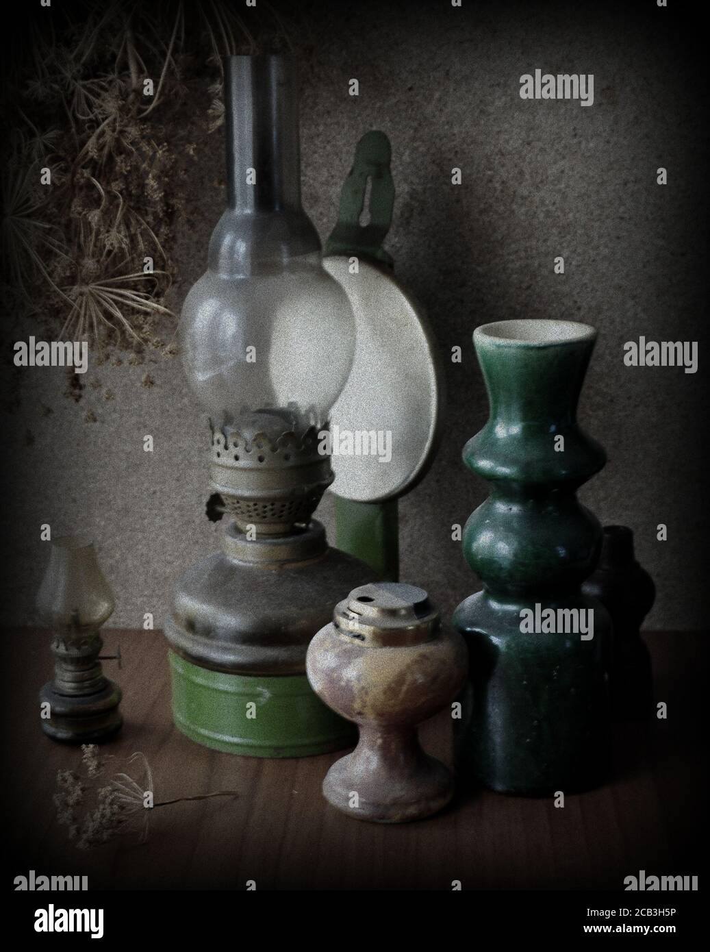 Still life with kerosene lamps, a vase and a lighter. Old dusty objects ...