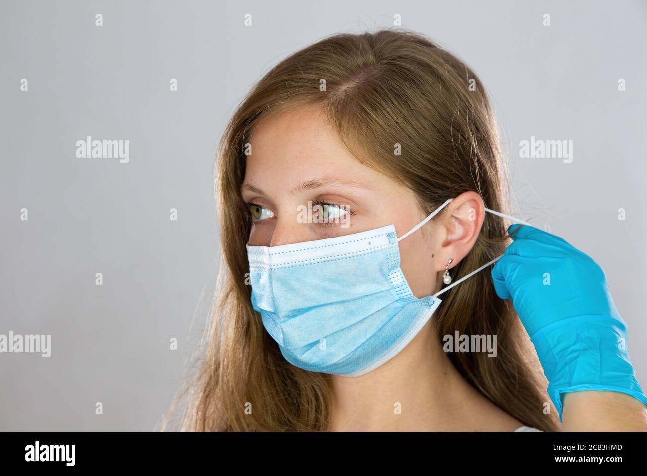 Woman putting on facemask hi-res stock photography and images - Alamy