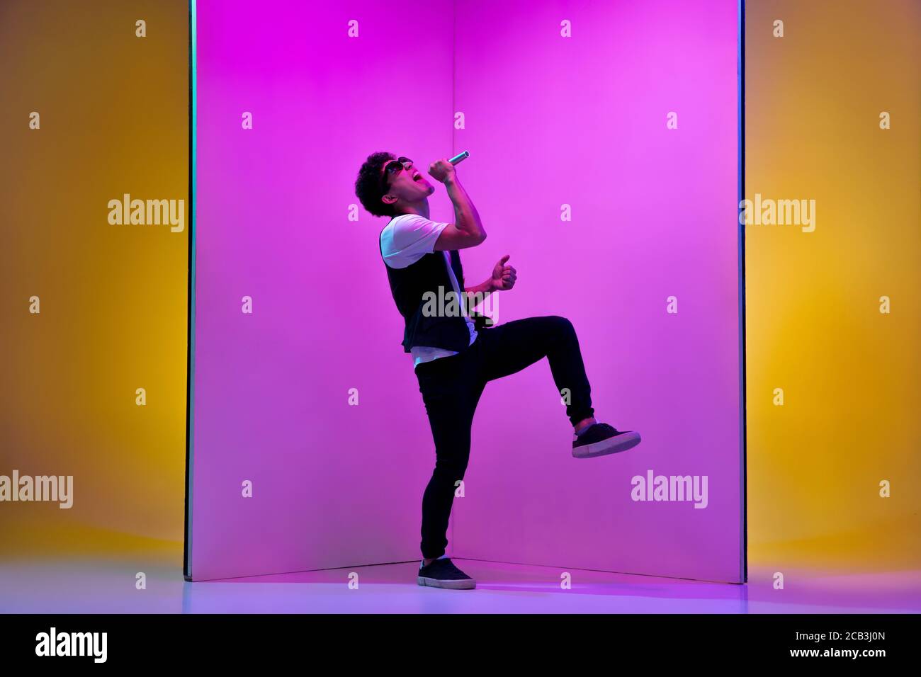 Celebrity. Young male musician, singer performing on pink-orange ...
