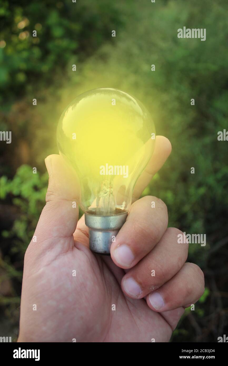 Person holding a glowing light bulb Stock Photo - Alamy