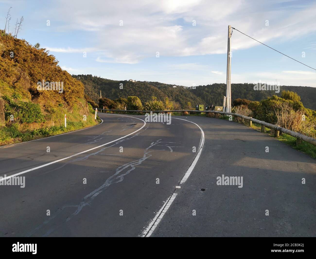 Closeup shot of a asphalt road curve with greenery on the side Stock ...