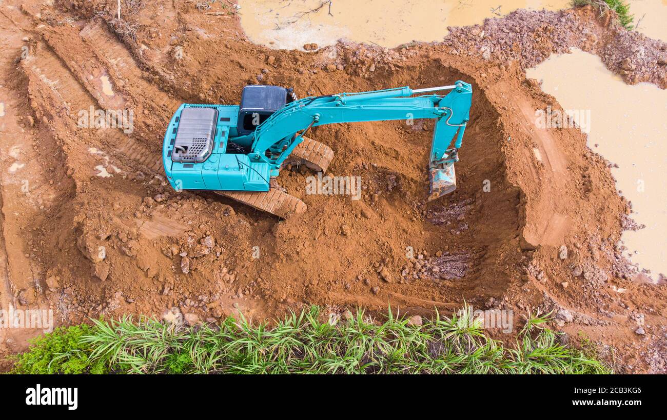 Backhoe loading soil into a truck then the truck carries soil for sale ...