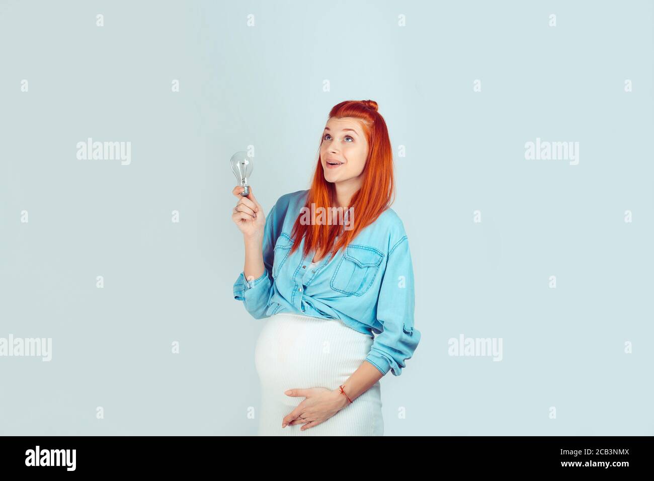 Wonderful young woman expecting baby and holding light bulb having ...
