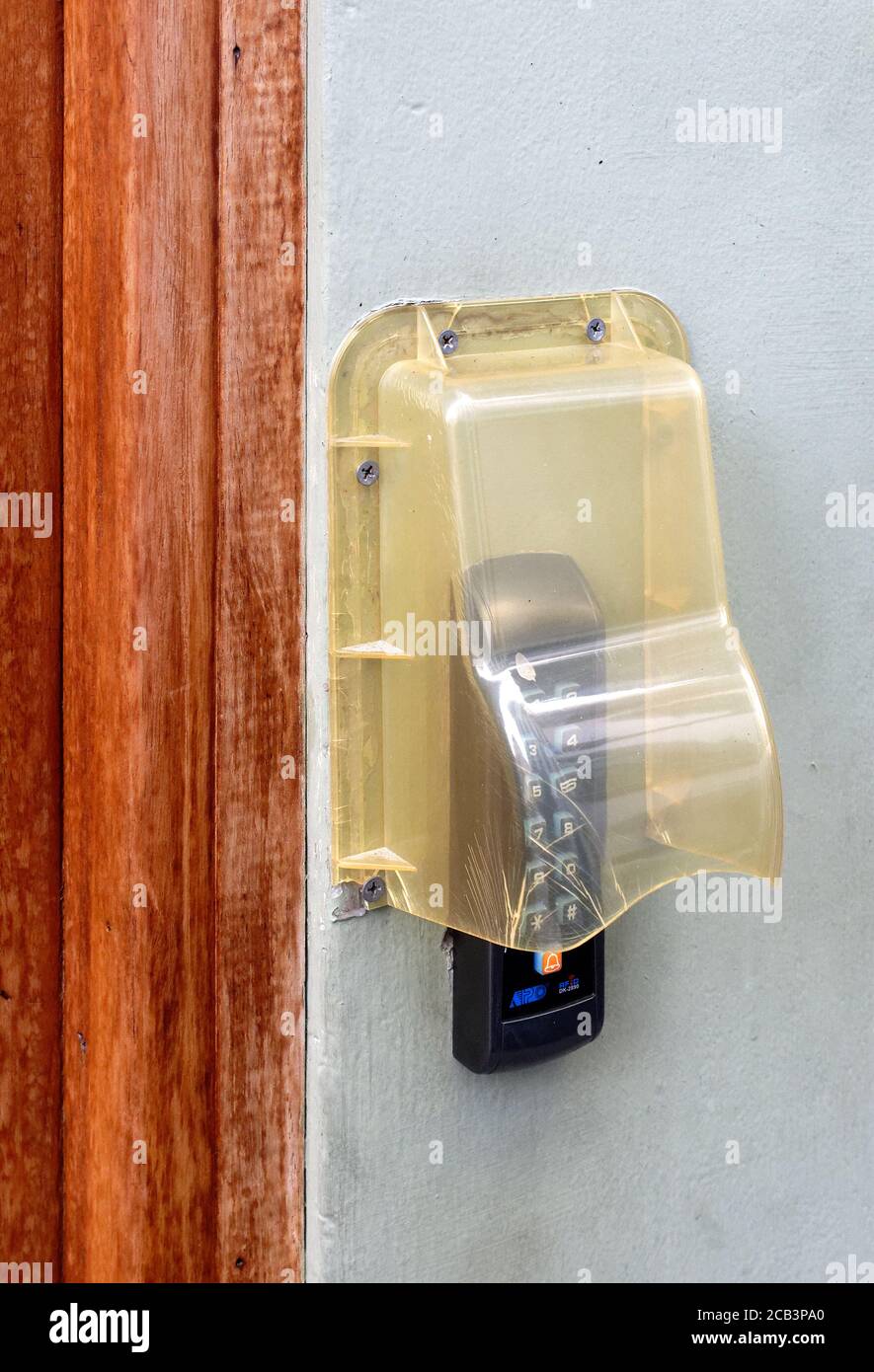 Electronic keypad entry system mounted by a wooden door under a ...
