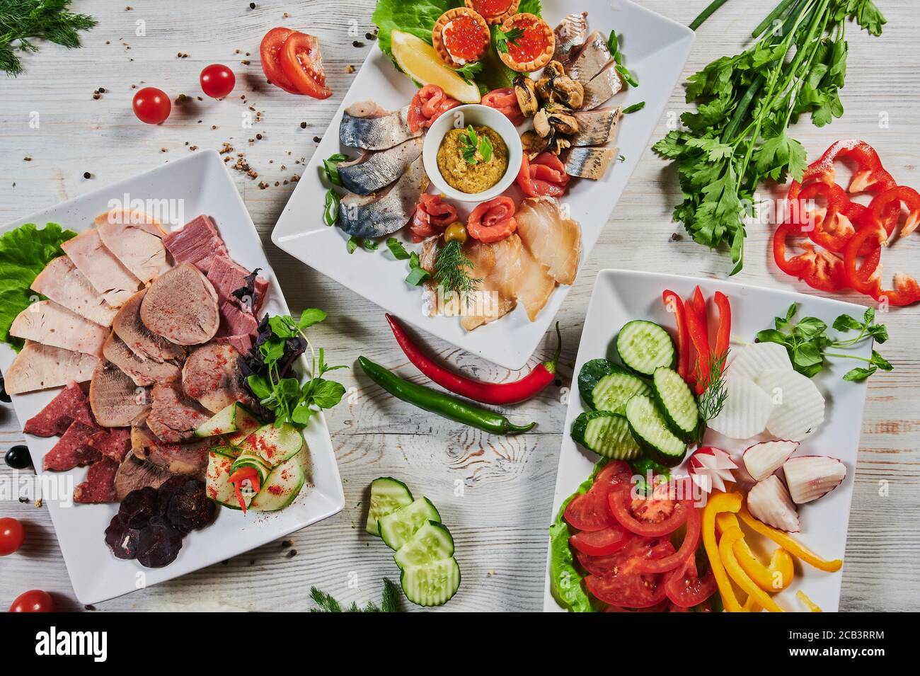 Dinner table with meat grill, roast new potatoes, vegetables, salads ...