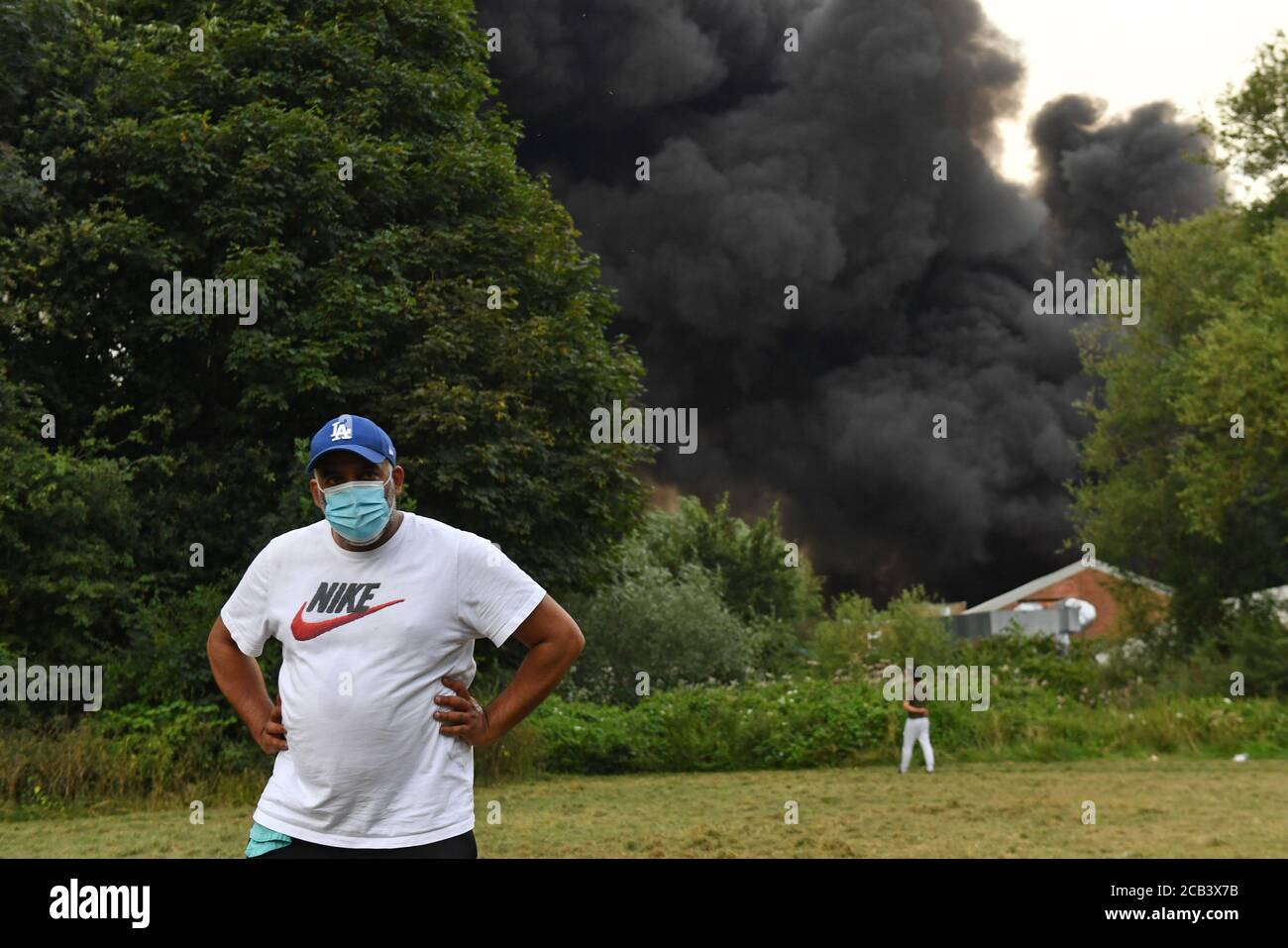 People watch on as smoke billows from a severe blaze on an industrial ...