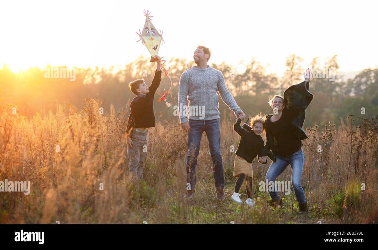 Beautiful young family with small children having fun in autumn nature ...