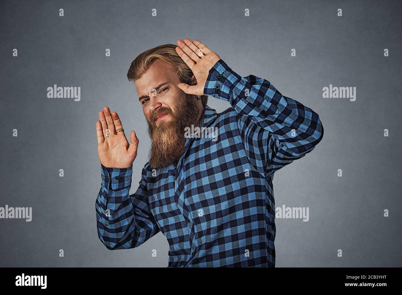 Bearded man scared with shocked facial expression trying to protect ...