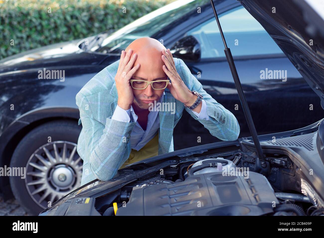 Broken car. Closeup portrait young stressed man having trouble with his ...