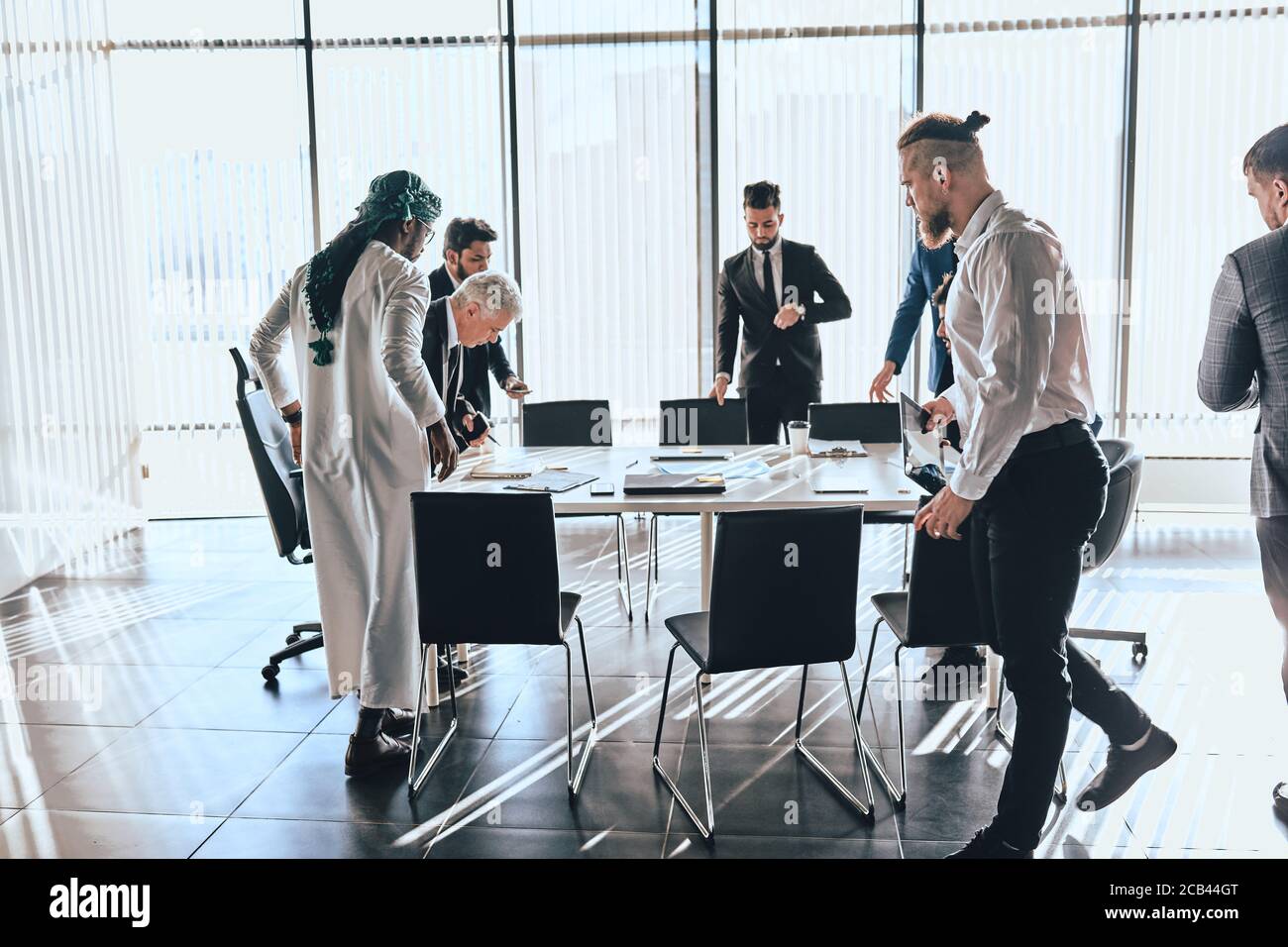 companions sitting down on chairs around the table. beginning the ...
