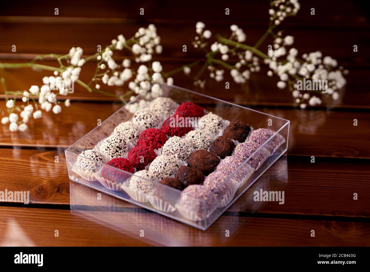Clear box of a colorful assortment of gourmet chocolate balls on a ...