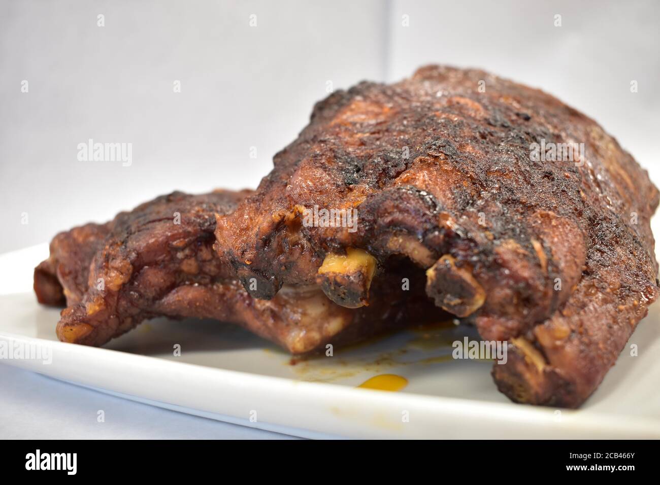 A Well-Done Rack of Ribs Plated on a White Background Stock Photo - Alamy