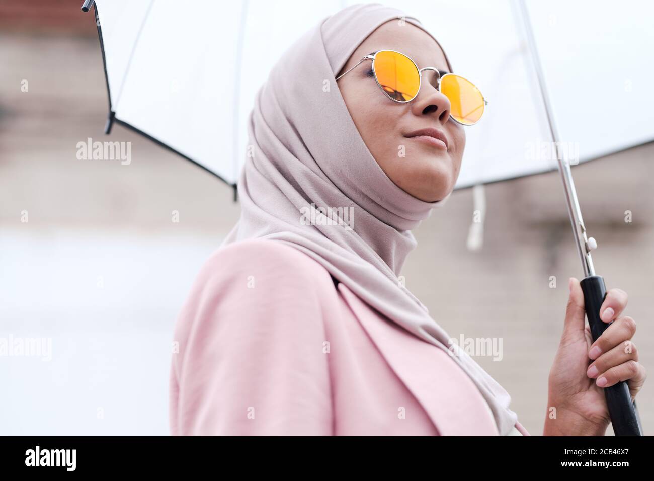 Below view of content confident young Muslim woman in sunglasses and ...