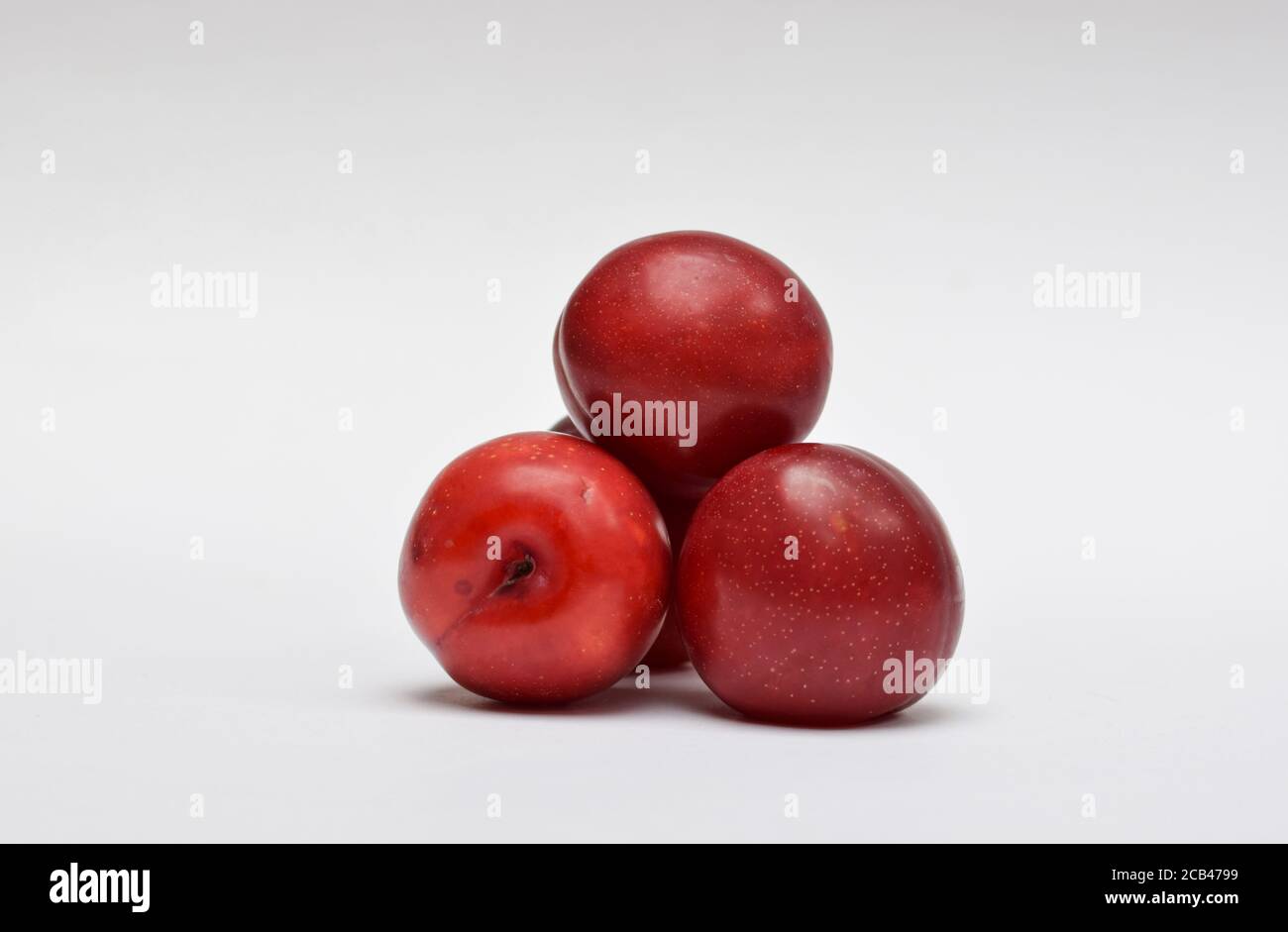 Raw Organic red Plums on white background, red maroon shades, fresh ...