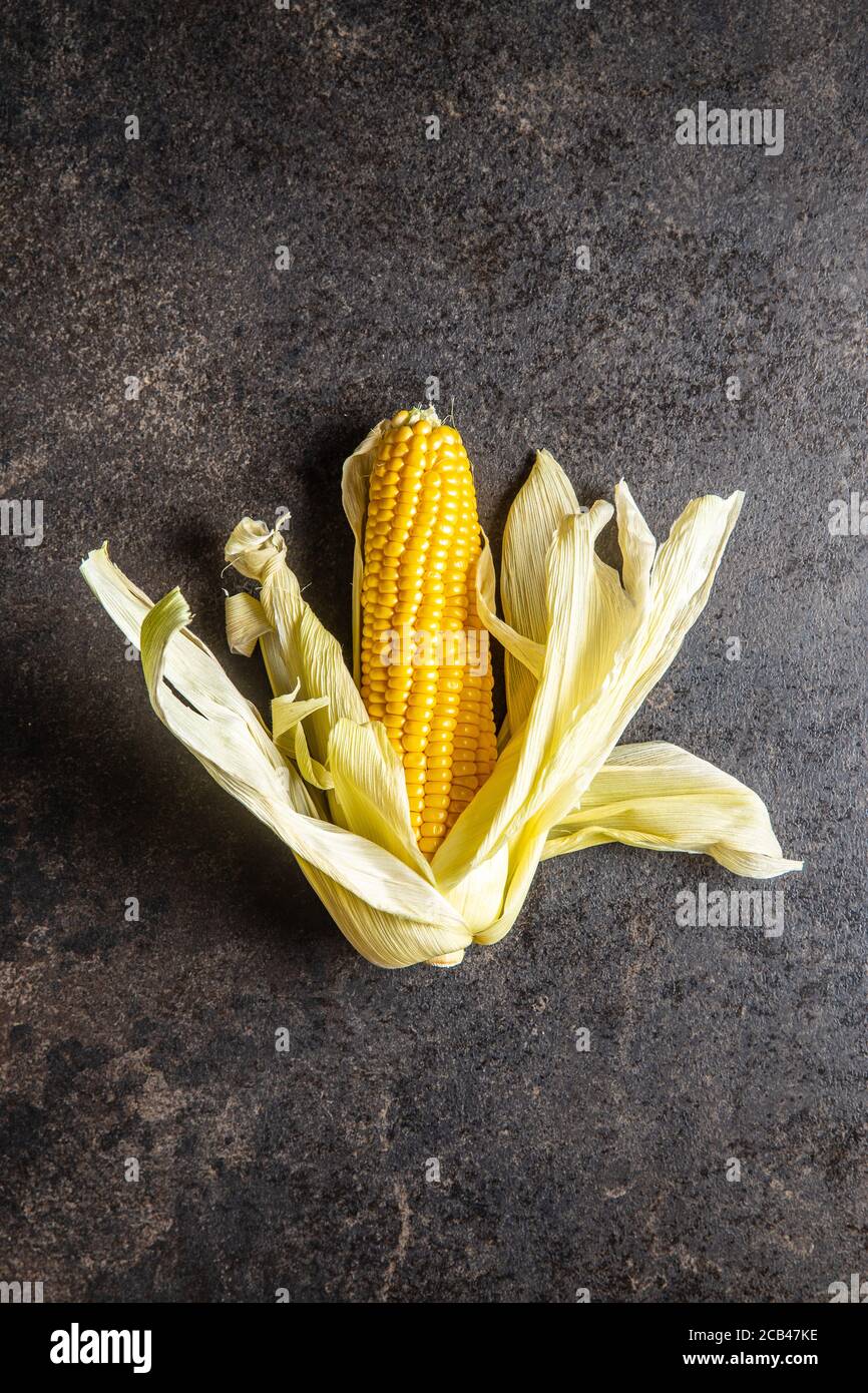 Uncooked corn cob on black table. Top view Stock Photo - Alamy